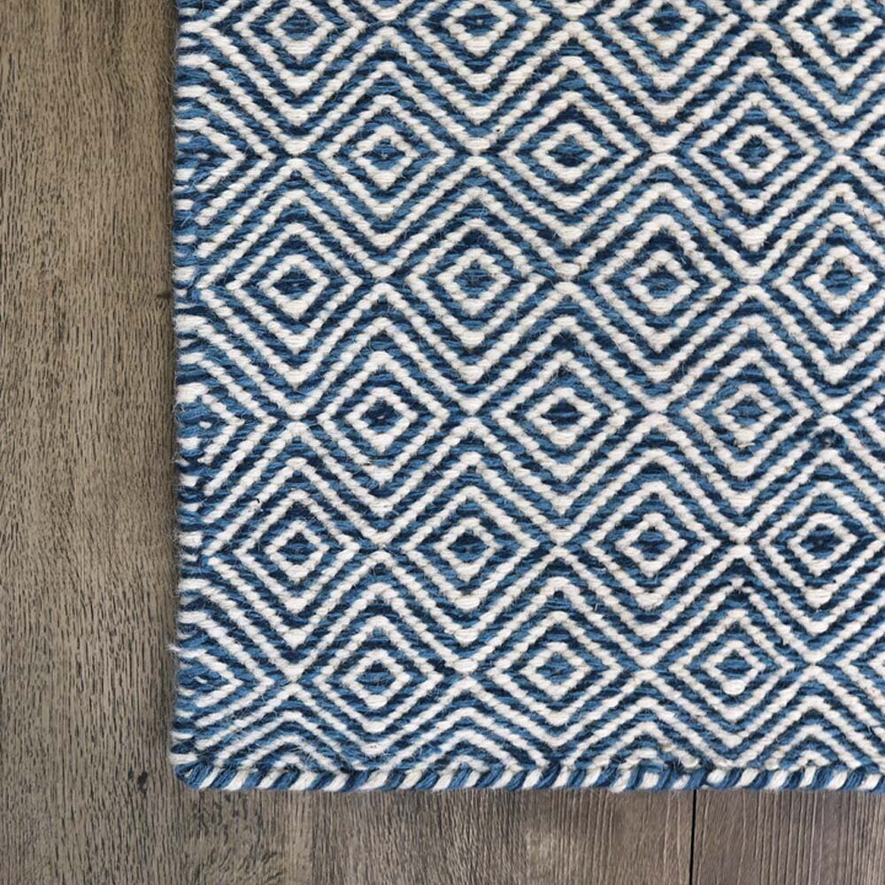 Handvävd ullmatta med klassiskt gåsögamönster i vitt på en blå botten ...